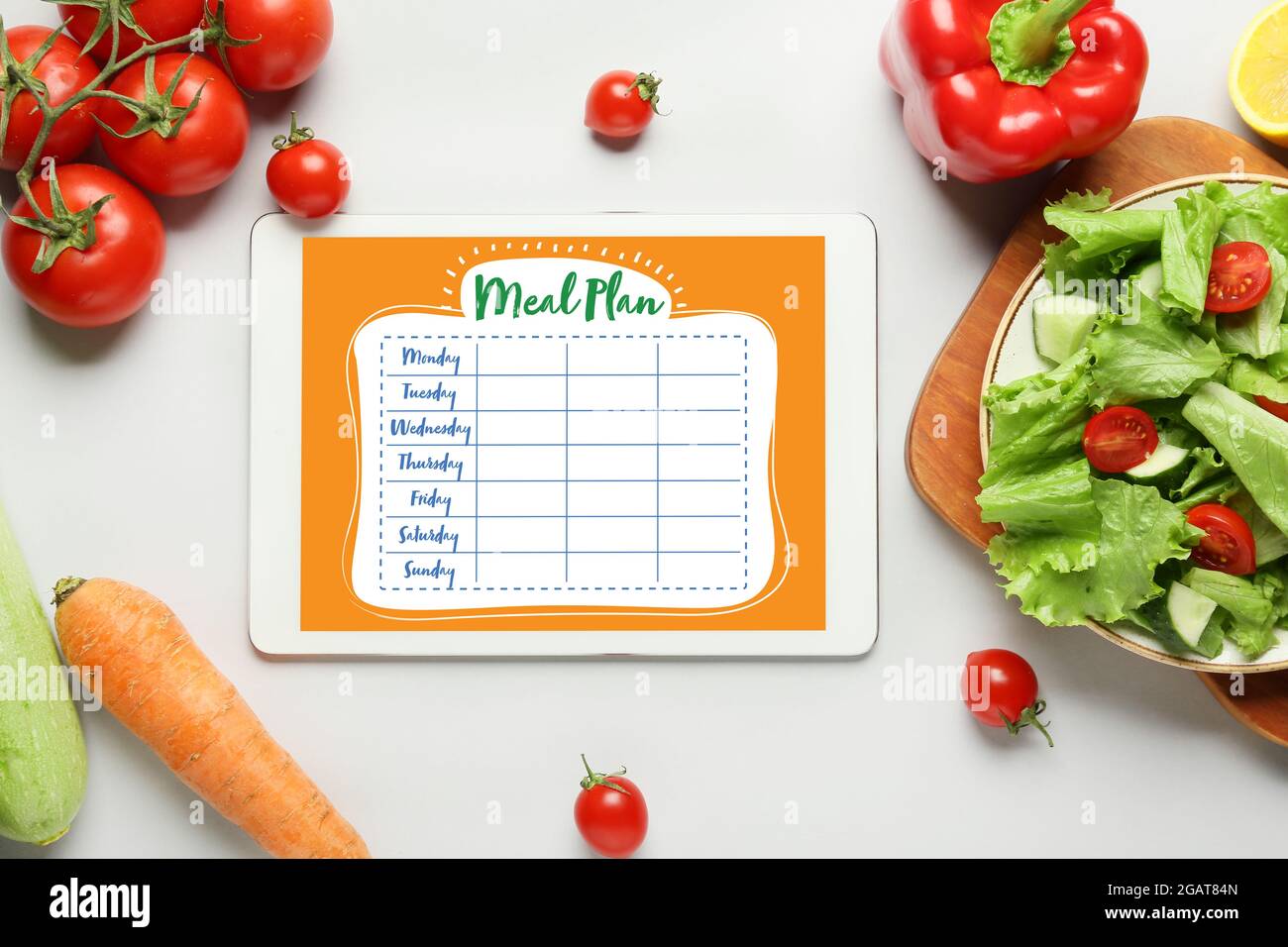 Healthy vegetables and tablet computer with diet plan on screen against ...