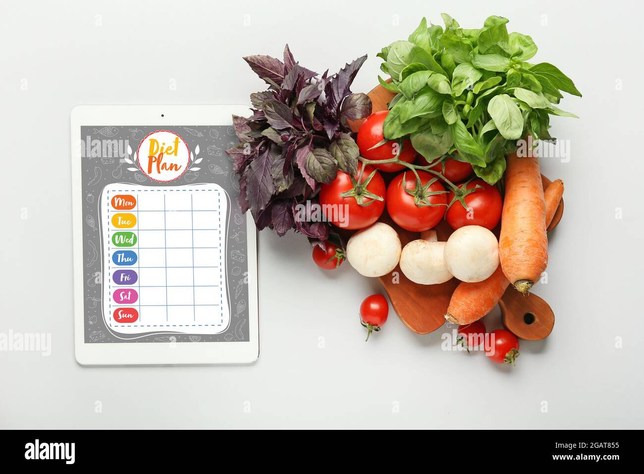 Healthy vegetables and tablet computer with diet plan on screen against ...