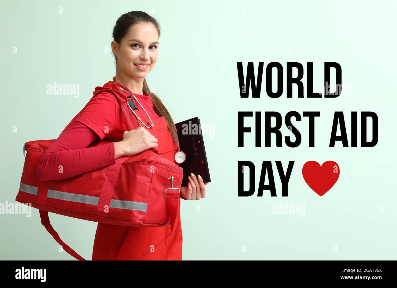 Female paramedic with bag and text WORLD FIRST AID DAY on light ...