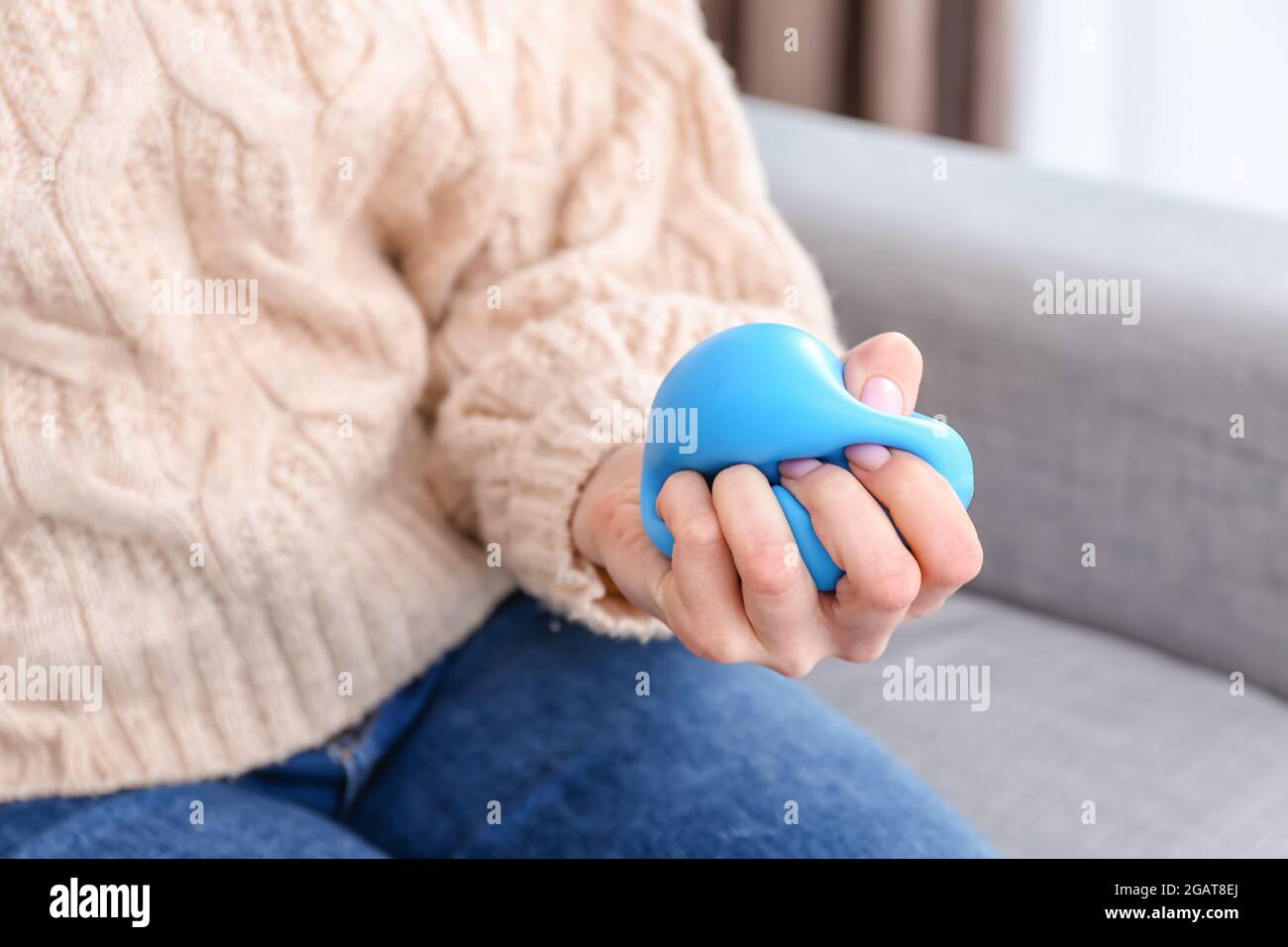 Woman squeezing stress ball, closeup Stock Photo - Alamy