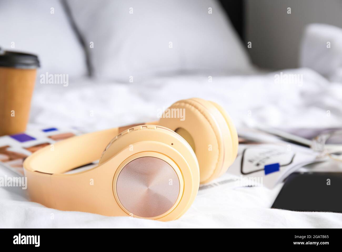 Modern headphones on bed, closeup Stock Photo - Alamy