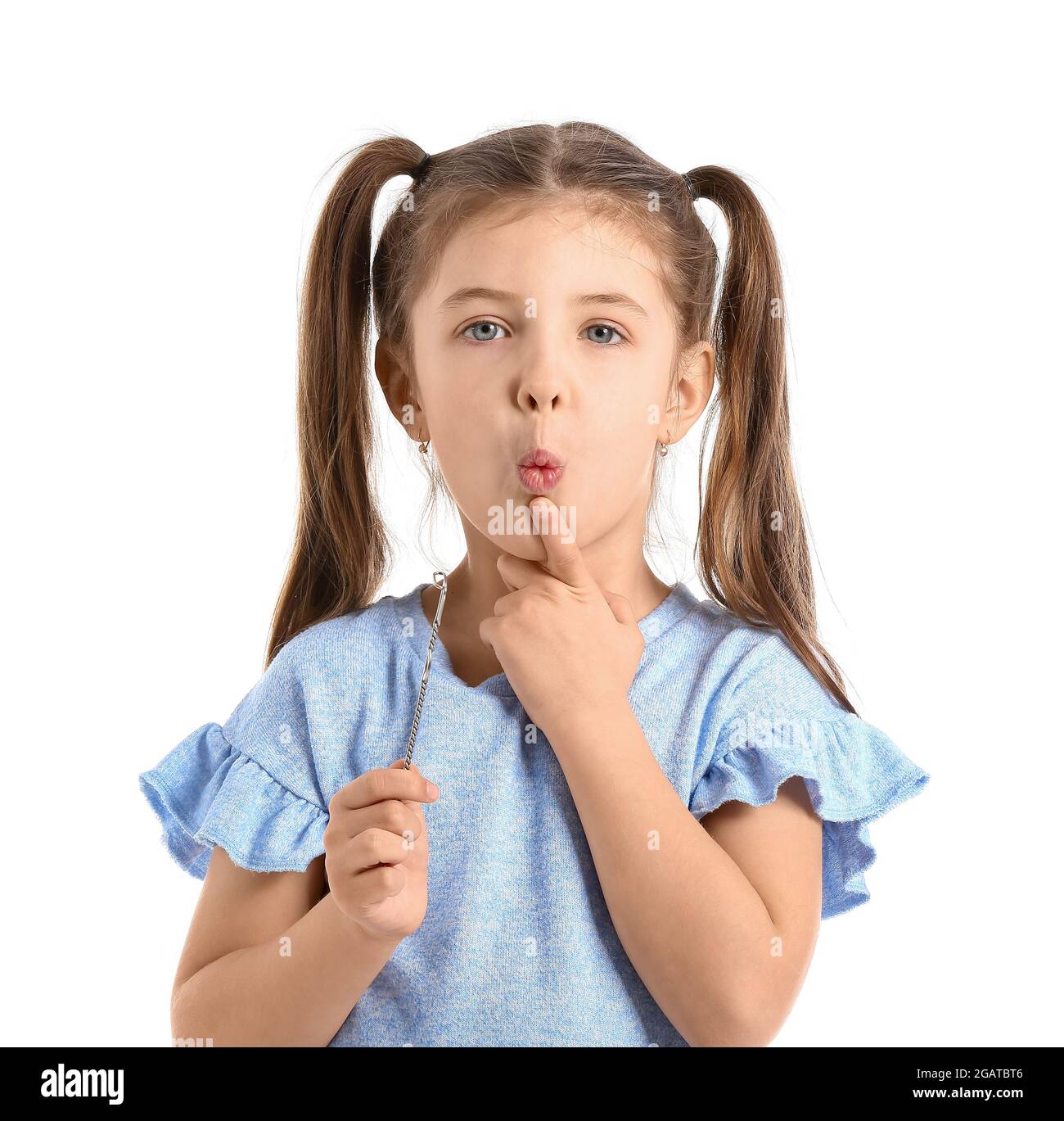 Little girl with logopedic tool for speech correction on white ...