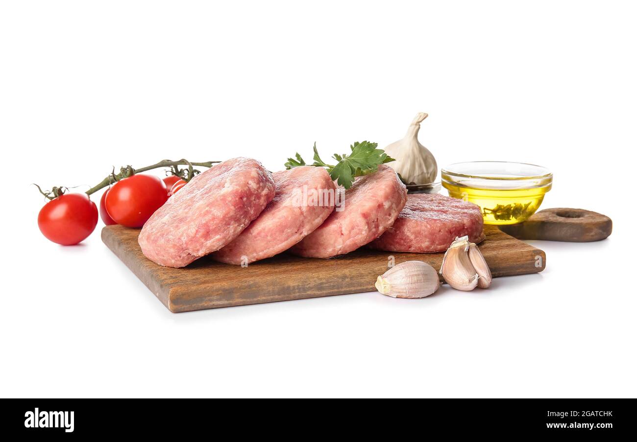 Wooden board with raw cutlets made of fresh forcemeat and ingredients ...
