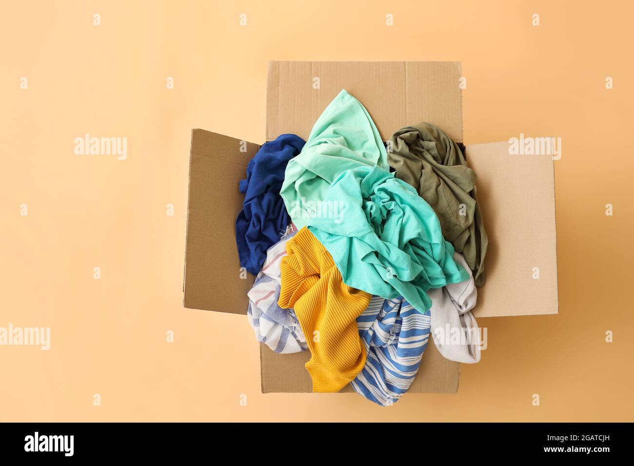 Wardrobe box with clothes on color background Stock Photo - Alamy