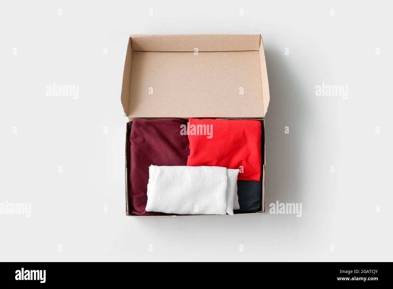 Wardrobe box with clothes on light background Stock Photo - Alamy