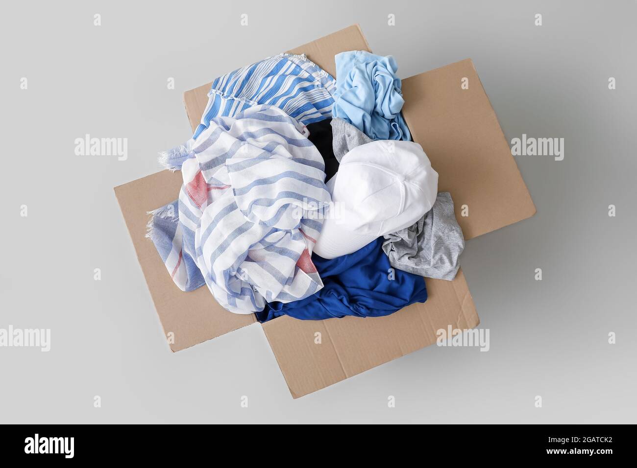 Wardrobe box with clothes on light background Stock Photo - Alamy