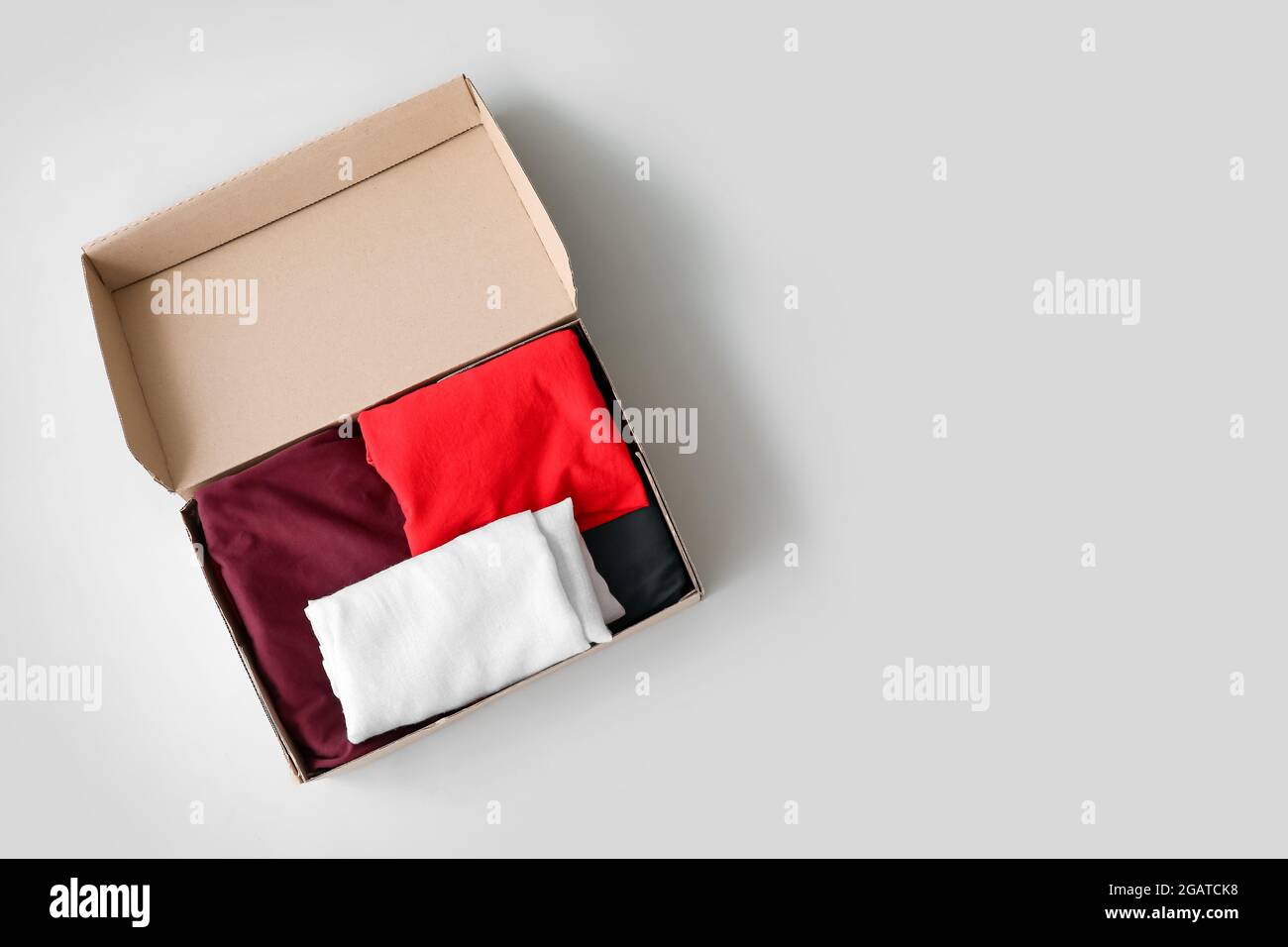 Wardrobe box with clothes on light background Stock Photo - Alamy