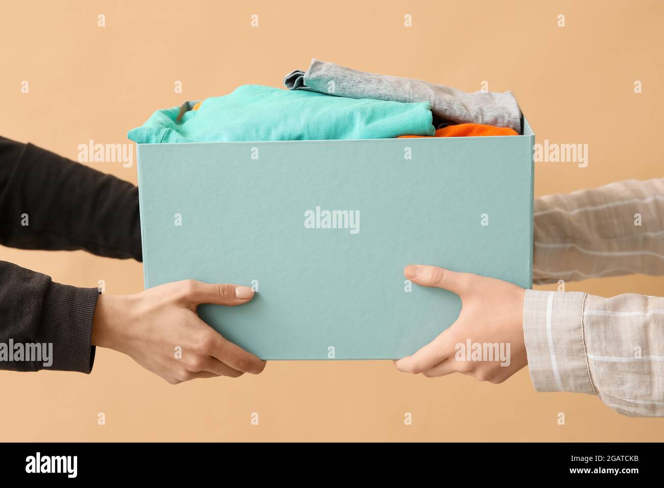 Women and wardrobe box with clothes on color background Stock Photo - Alamy