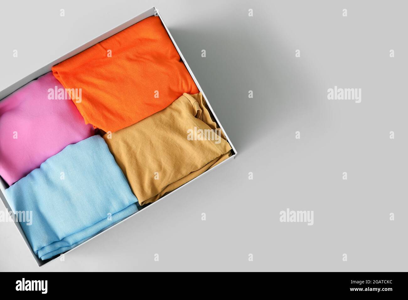 Wardrobe box with clothes on light background Stock Photo - Alamy