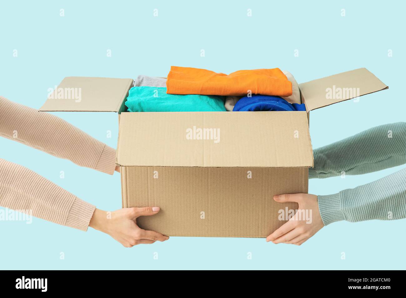 Women and wardrobe box with clothes on color background Stock Photo - Alamy