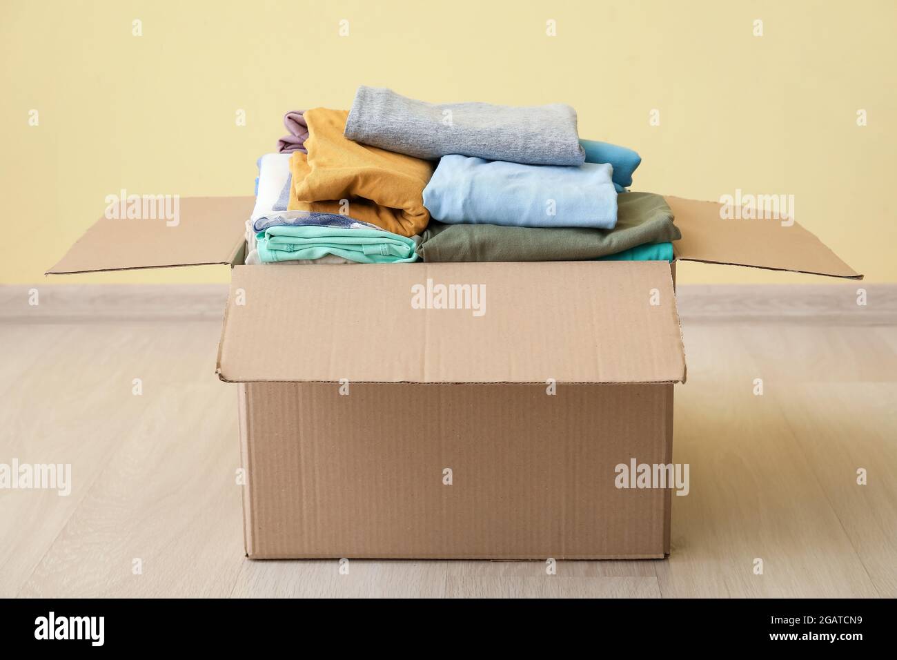 Wardrobe box with clothes near color wall Stock Photo - Alamy