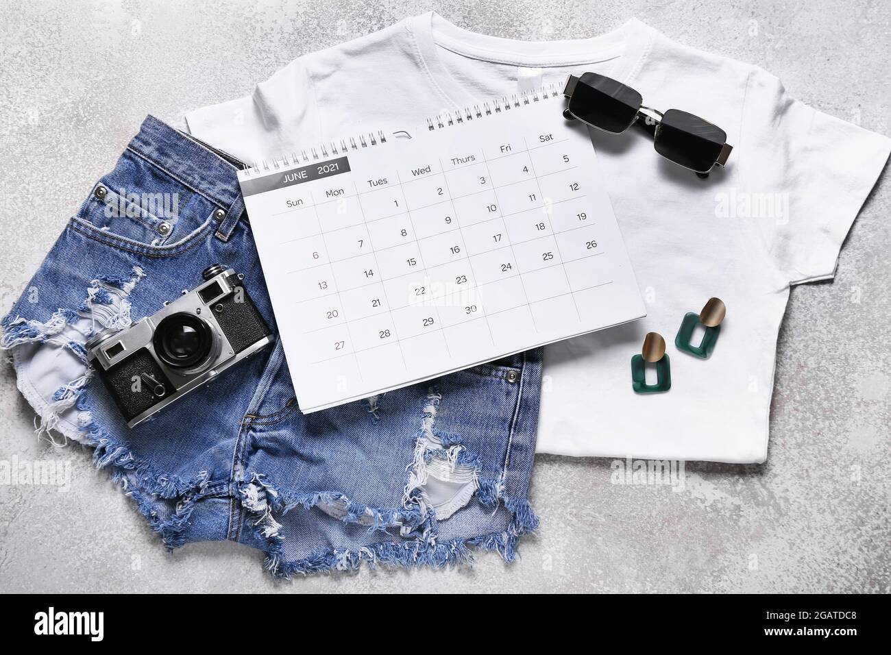 Calendar, female clothes and accessories on light background Stock ...