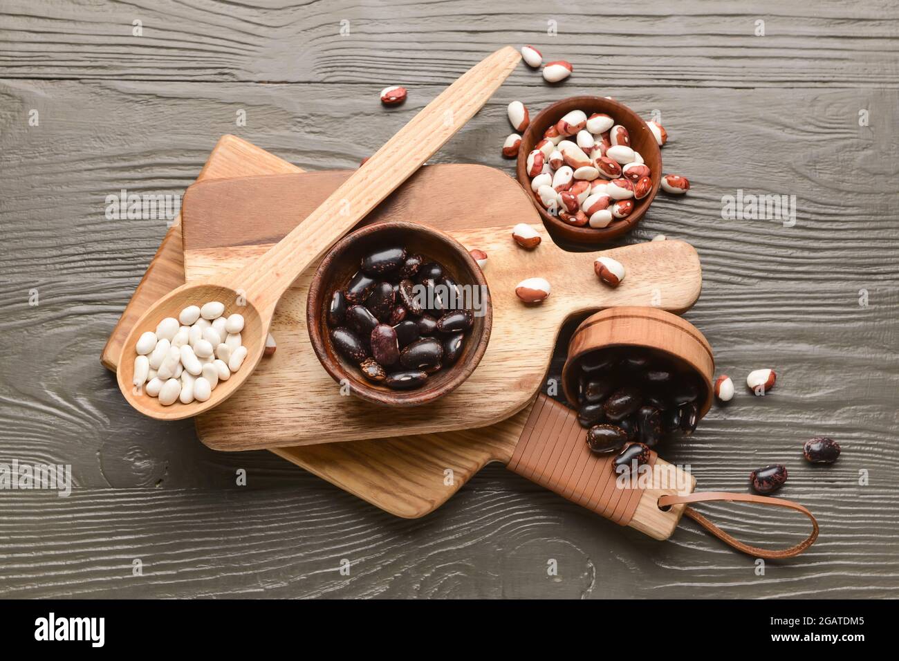 Composition with different types of beans on dark wooden background ...