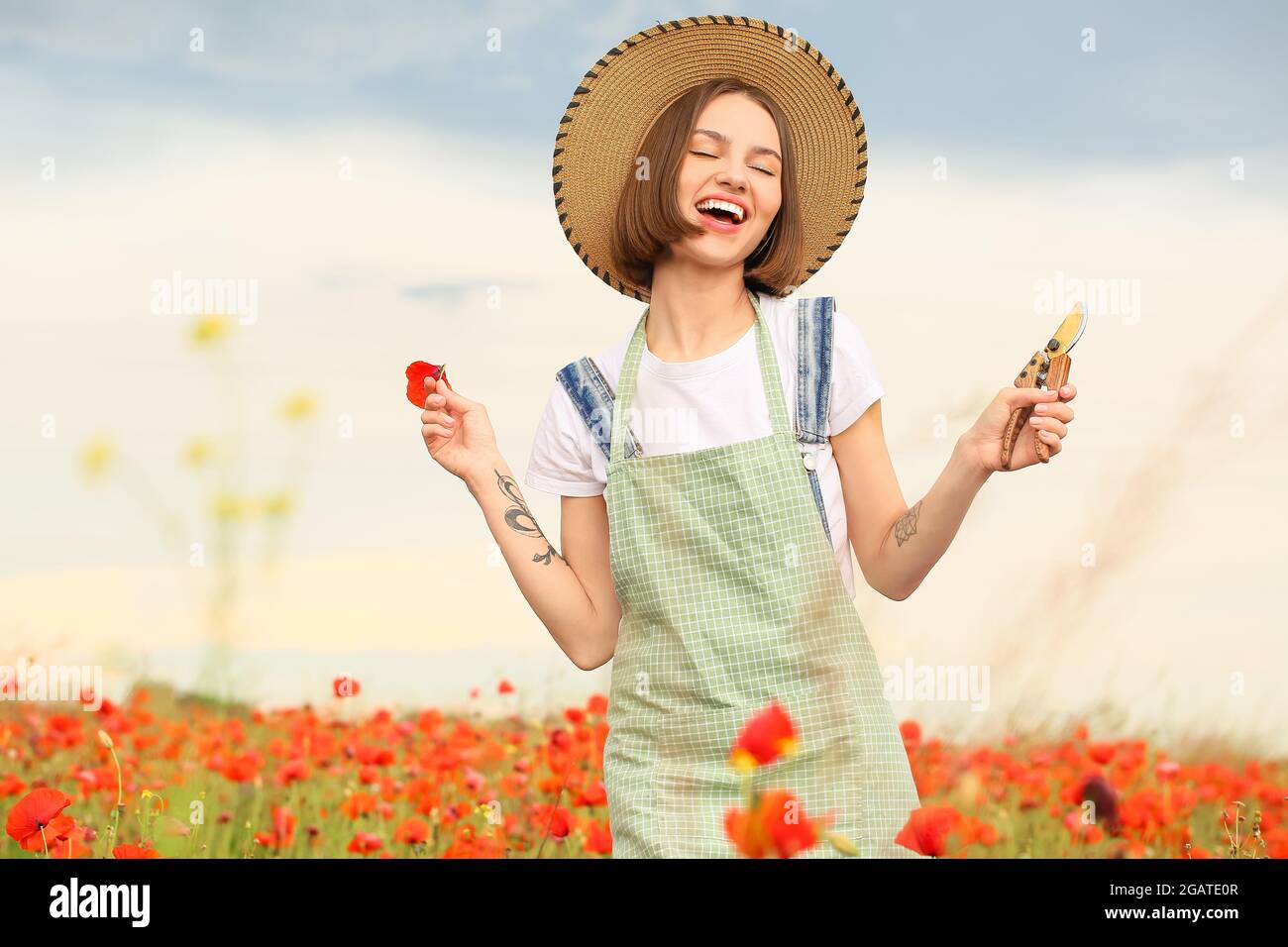 Beautiful female farmer in poppy field Stock Photo - Alamy