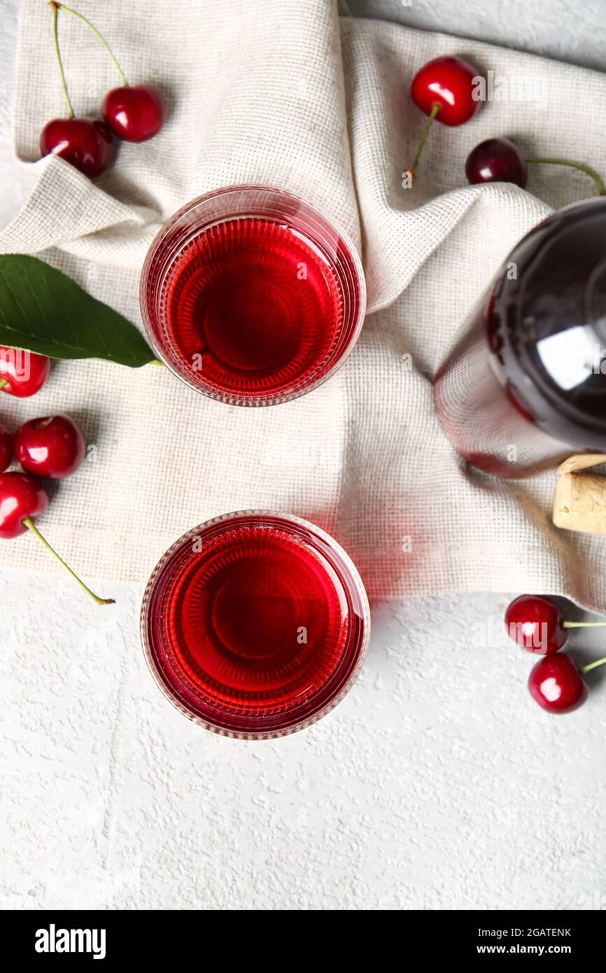 Glasses of sweet cherry wine on light background Stock Photo - Alamy