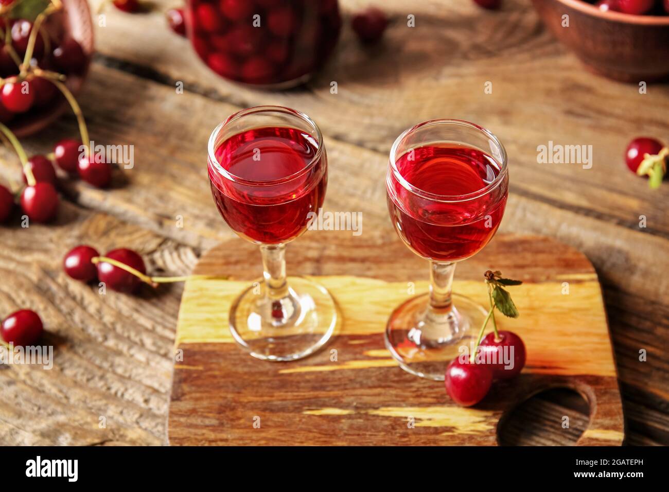 Glasses of sweet cherry wine on wooden background Stock Photo - Alamy