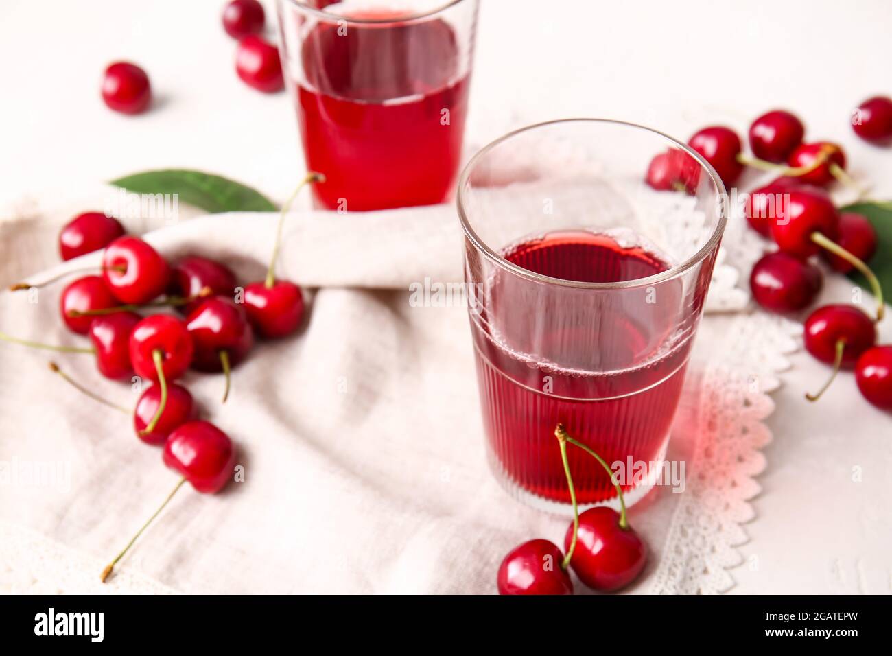 Glasses of sweet cherry wine on light background Stock Photo - Alamy