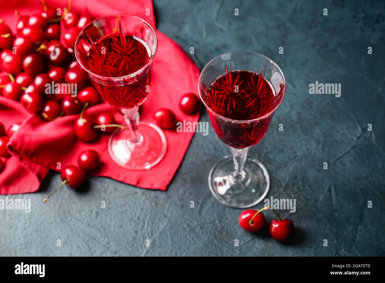 Composition with glasses of sweet cherry wine on color background Stock ...
