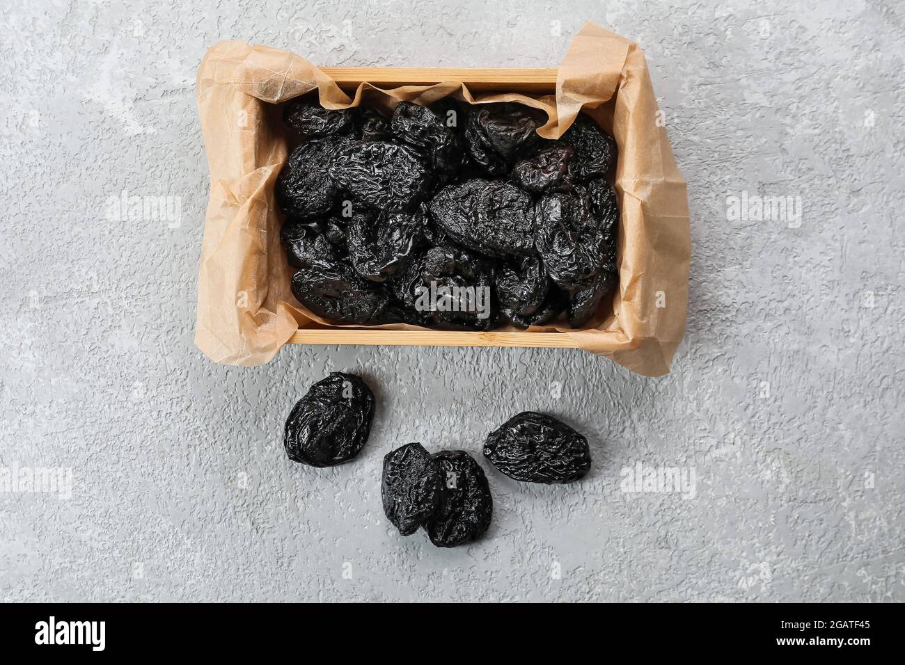 Wooden box with tasty prunes on grey background Stock Photo - Alamy