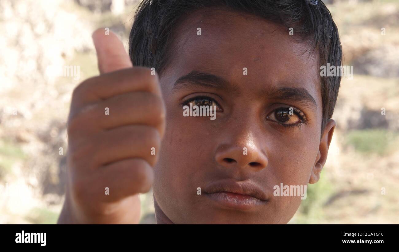 A poor Indian kid showing thumbs up Stock Photo - Alamy