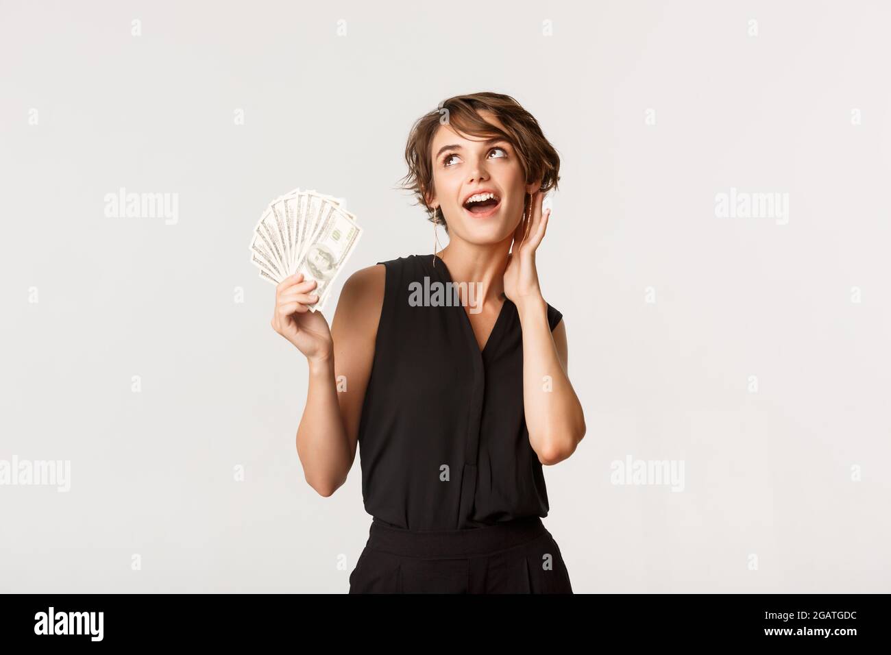 Gorgeous rich girl showing money and looking sassy, standing over white ...