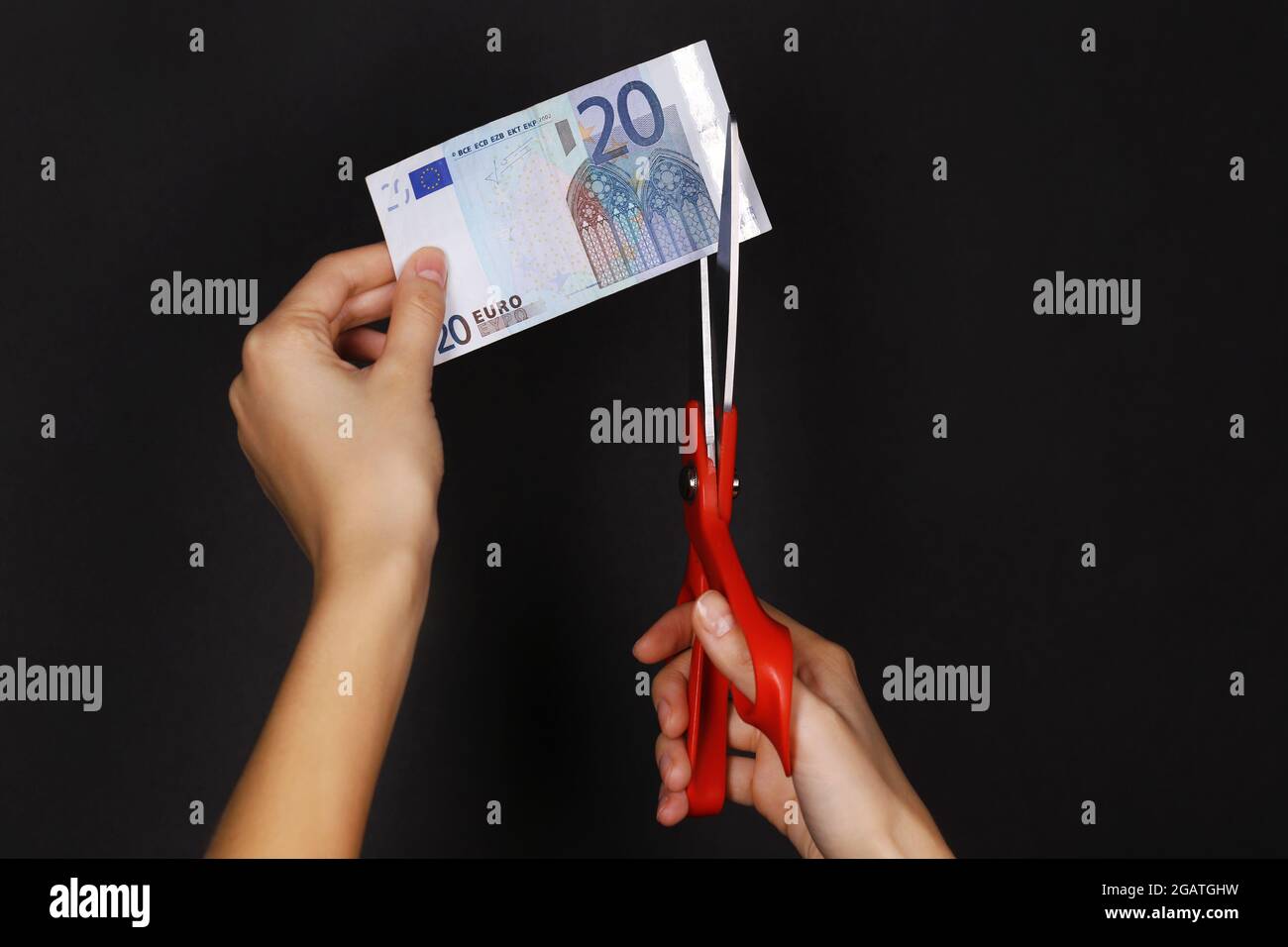 Hands with scissors cutting Euro banknote, on black background Stock ...