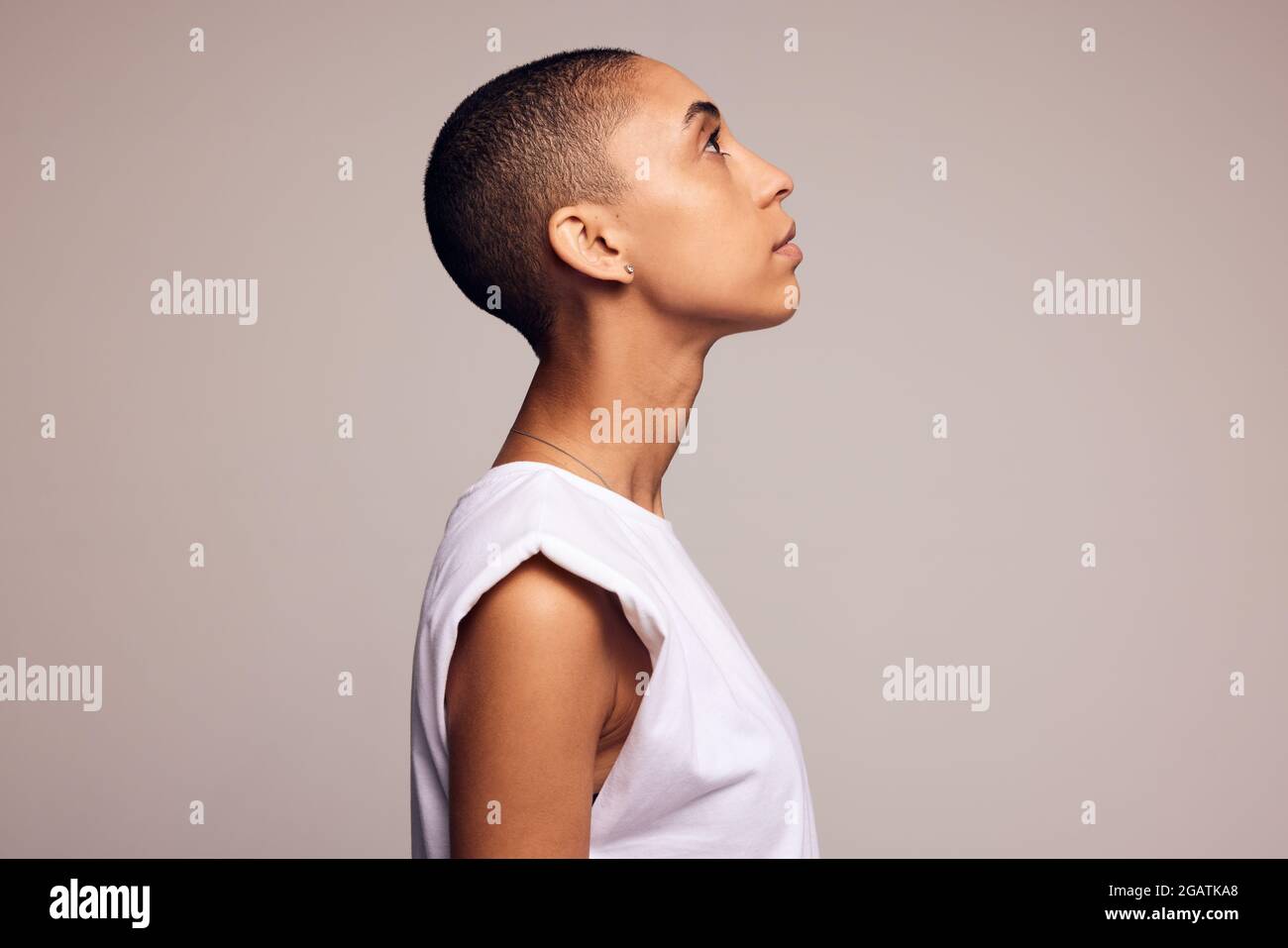 Profile view of an androgynous woman with shaved head. Young female ...