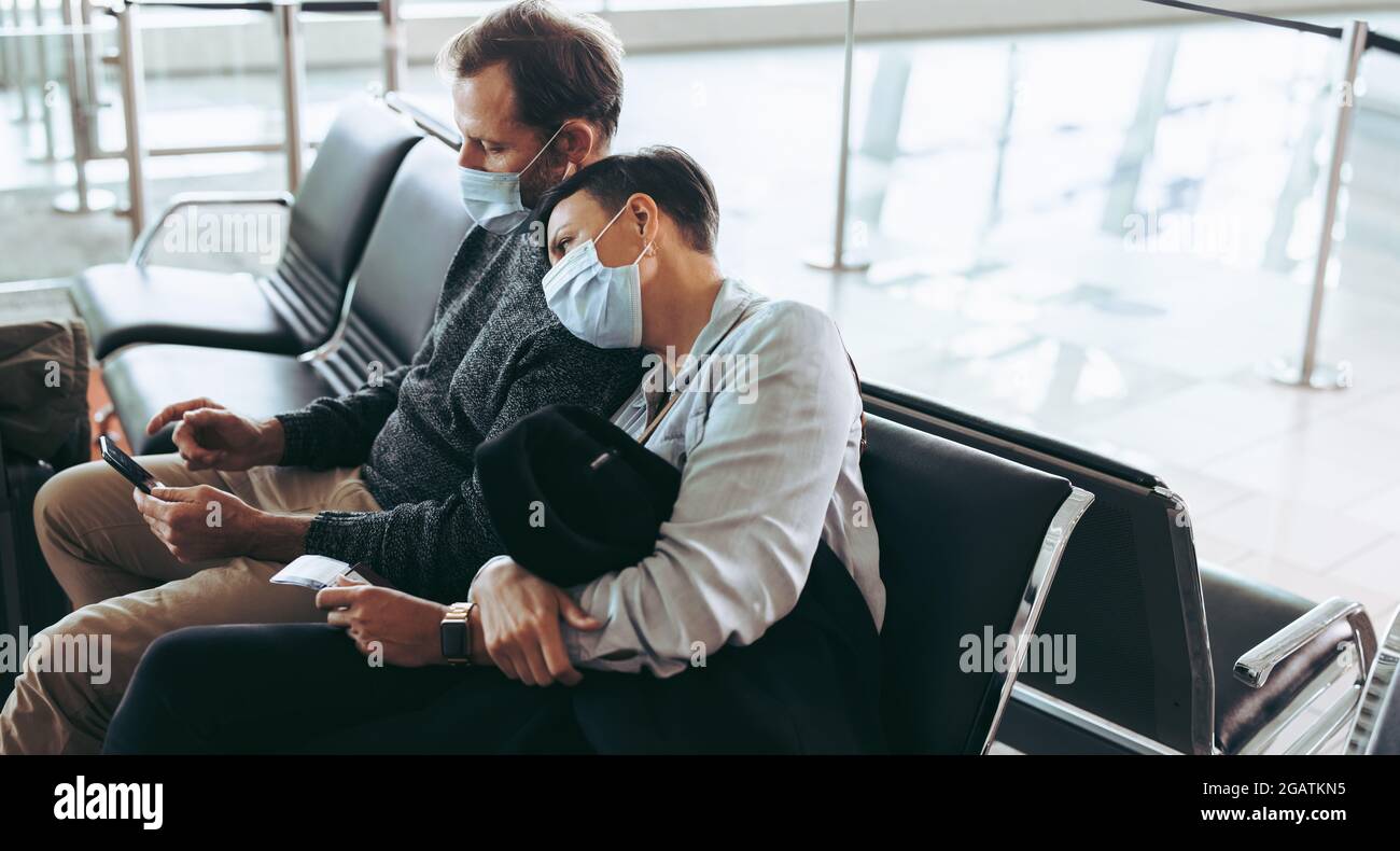 Man and woman traveler during pandemic sitting at airport terminal ...
