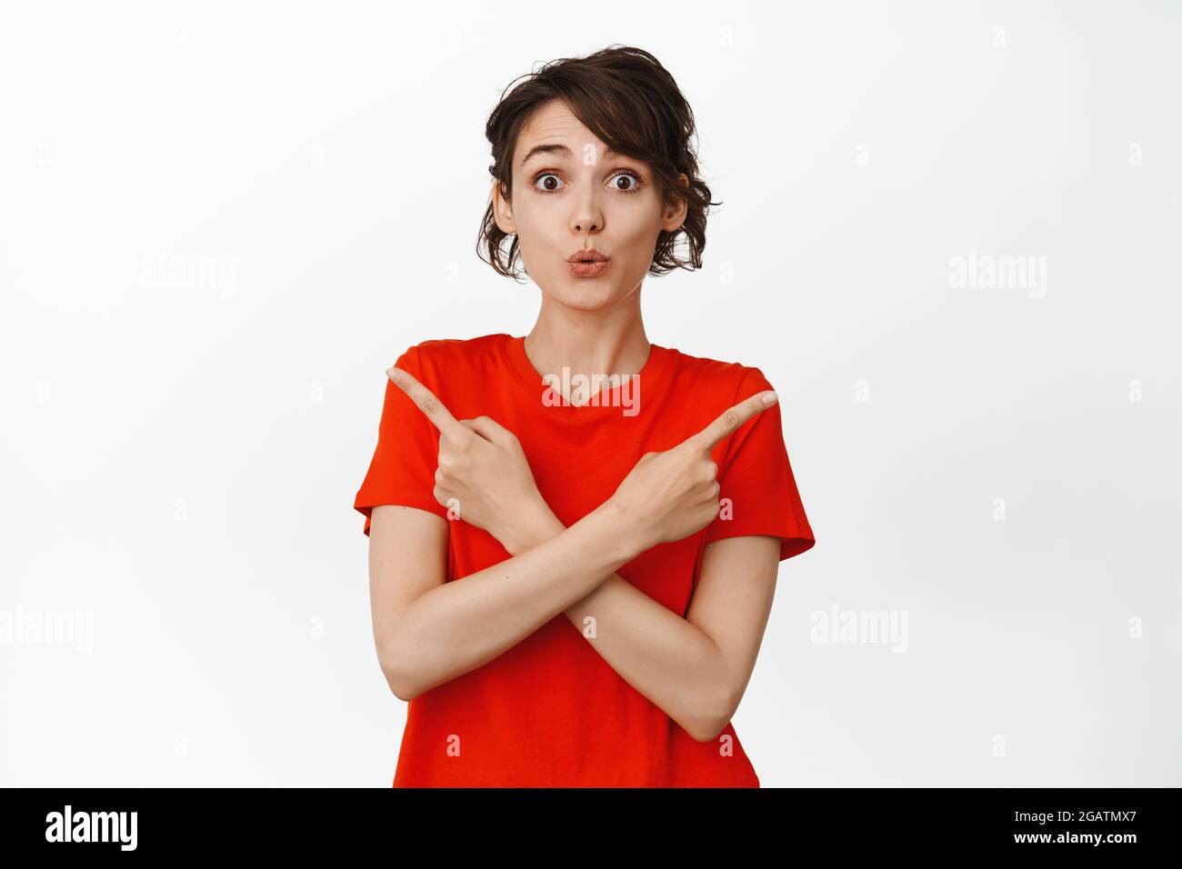 Cute young woman pointing sideways, showing left and rights sides copy ...