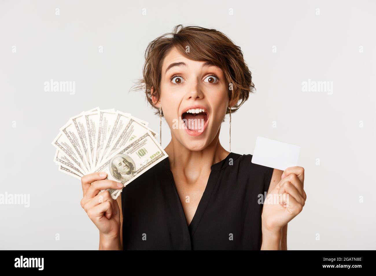 Close-up of amazed young woman open mouth fascinated, holding money and ...