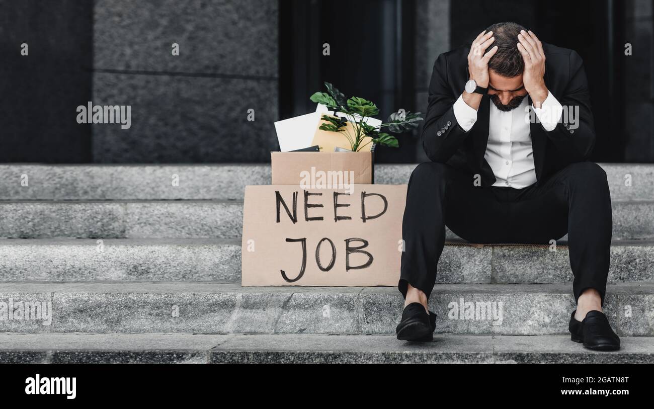Hire me on job, please. Depressed businessman sitting outdoors with box ...