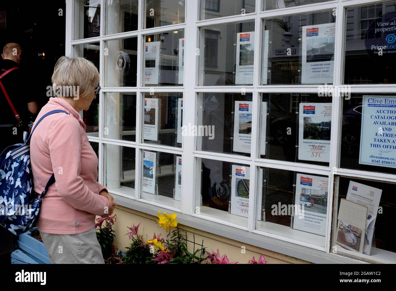 woman looking at a estate agents shop window display in broadstairs ...