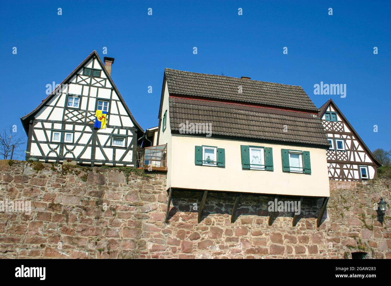 old house built over medieval city wall next to two half-timbered ...