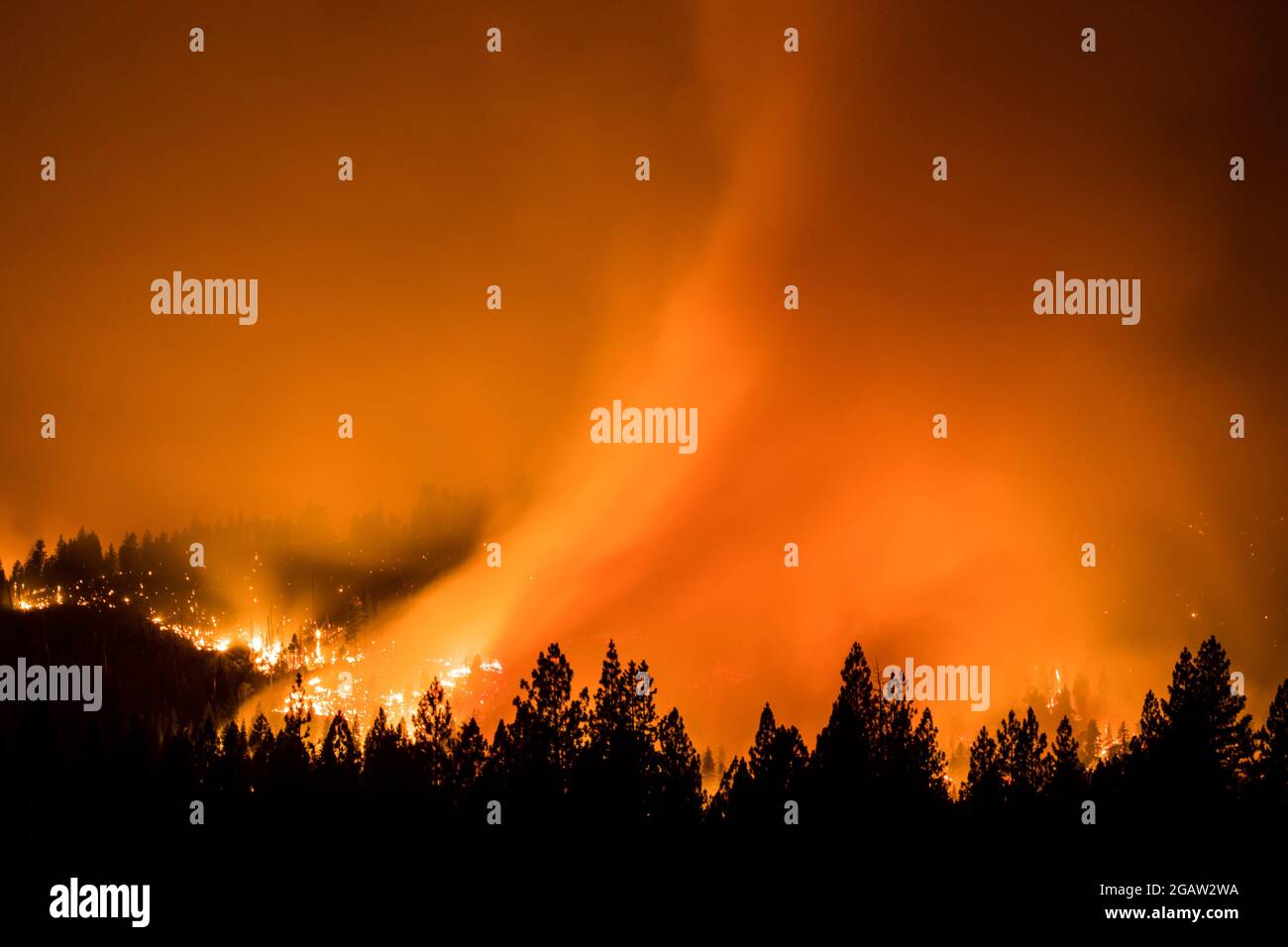 The Dixie fire burns through the night illuminating the smoke above ...