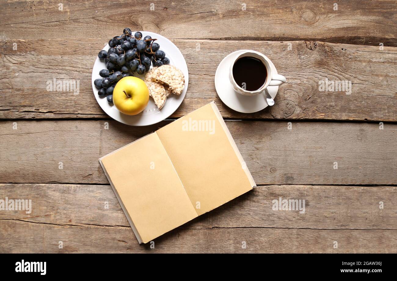 Open book and snack on wooden table background Stock Photo - Alamy