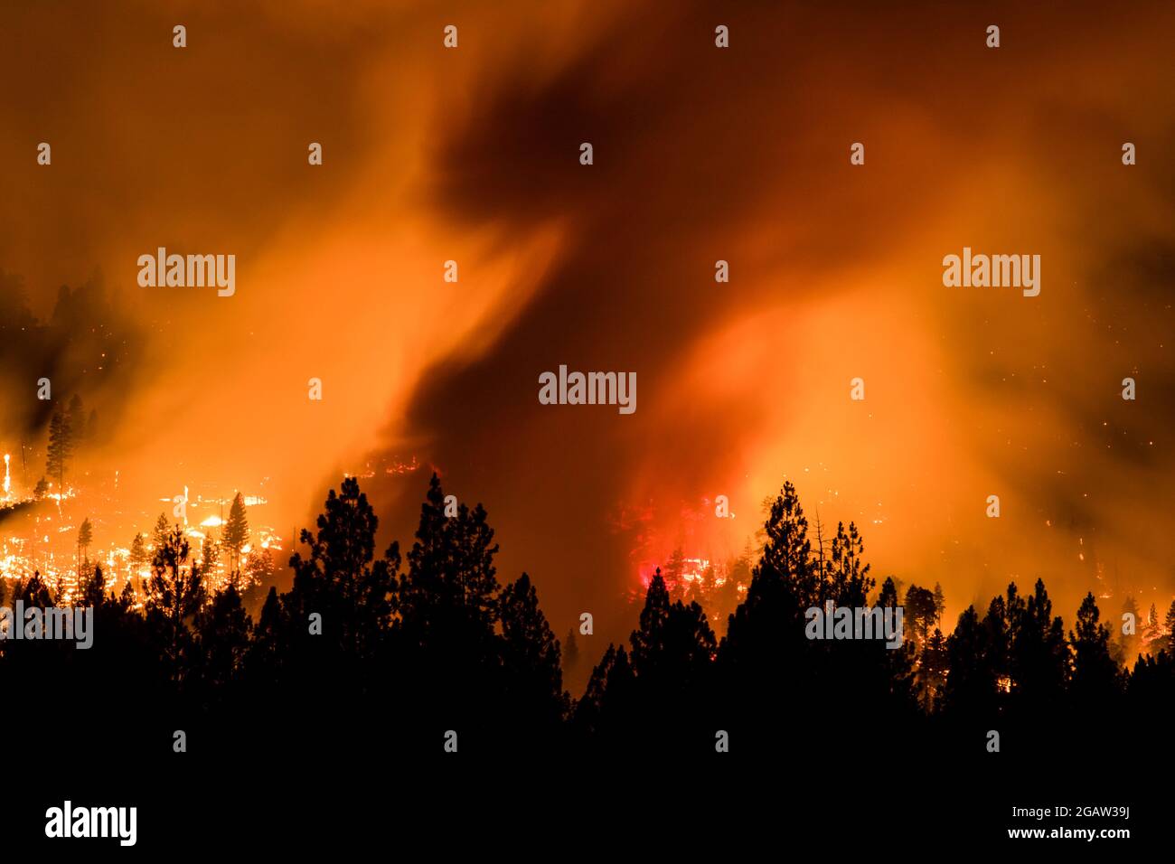 The Dixie fire burns through the night illuminating the smoke above ...