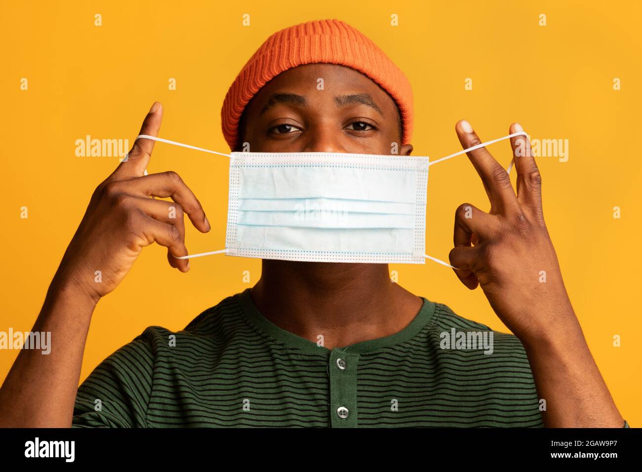 Coronavirus Spread Prevention. Portrait Of Young Black Guy Putting On ...
