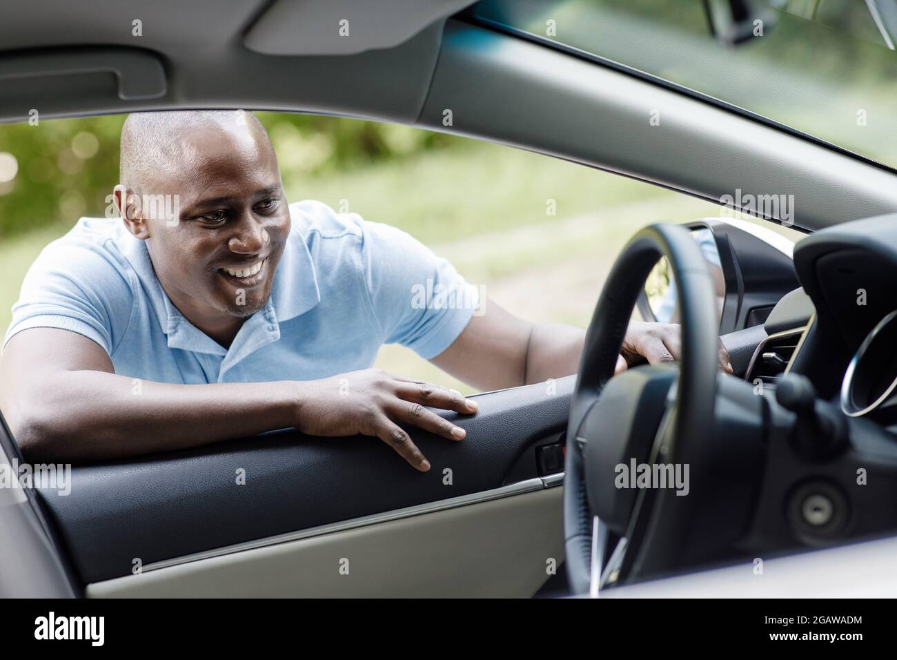 Happy african american man customer looking inside new car, checking ...