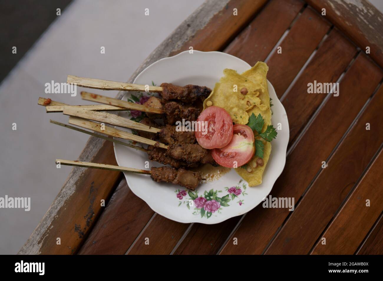 A serving of Balinese fish satay topped with fresh tomatoes, celery and ...