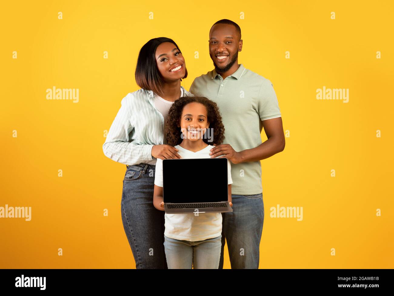 Excited black family of three showing laptop with blank black screen ...