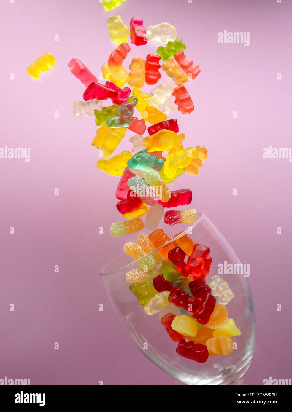 Gummy candies fly out of the glass Stock Photo - Alamy