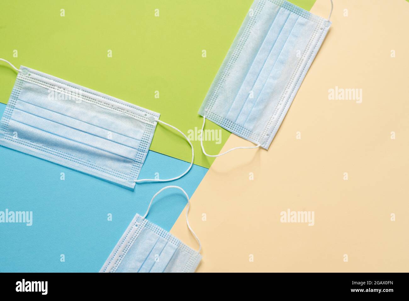 The three clean disposable masks lying on a colored background in the ...