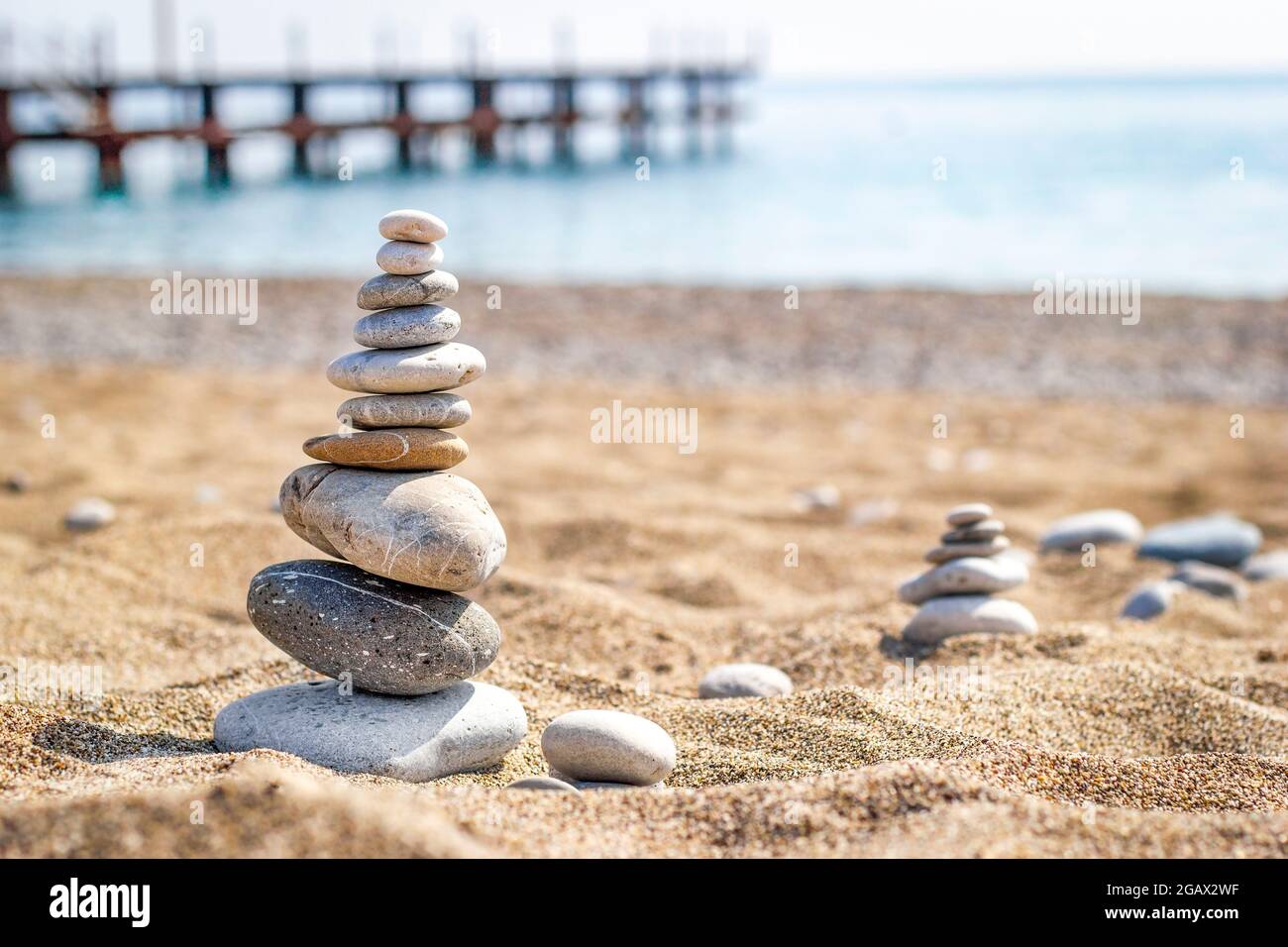 Pyramid of stones for meditation lying on the sand on blurred sea ...