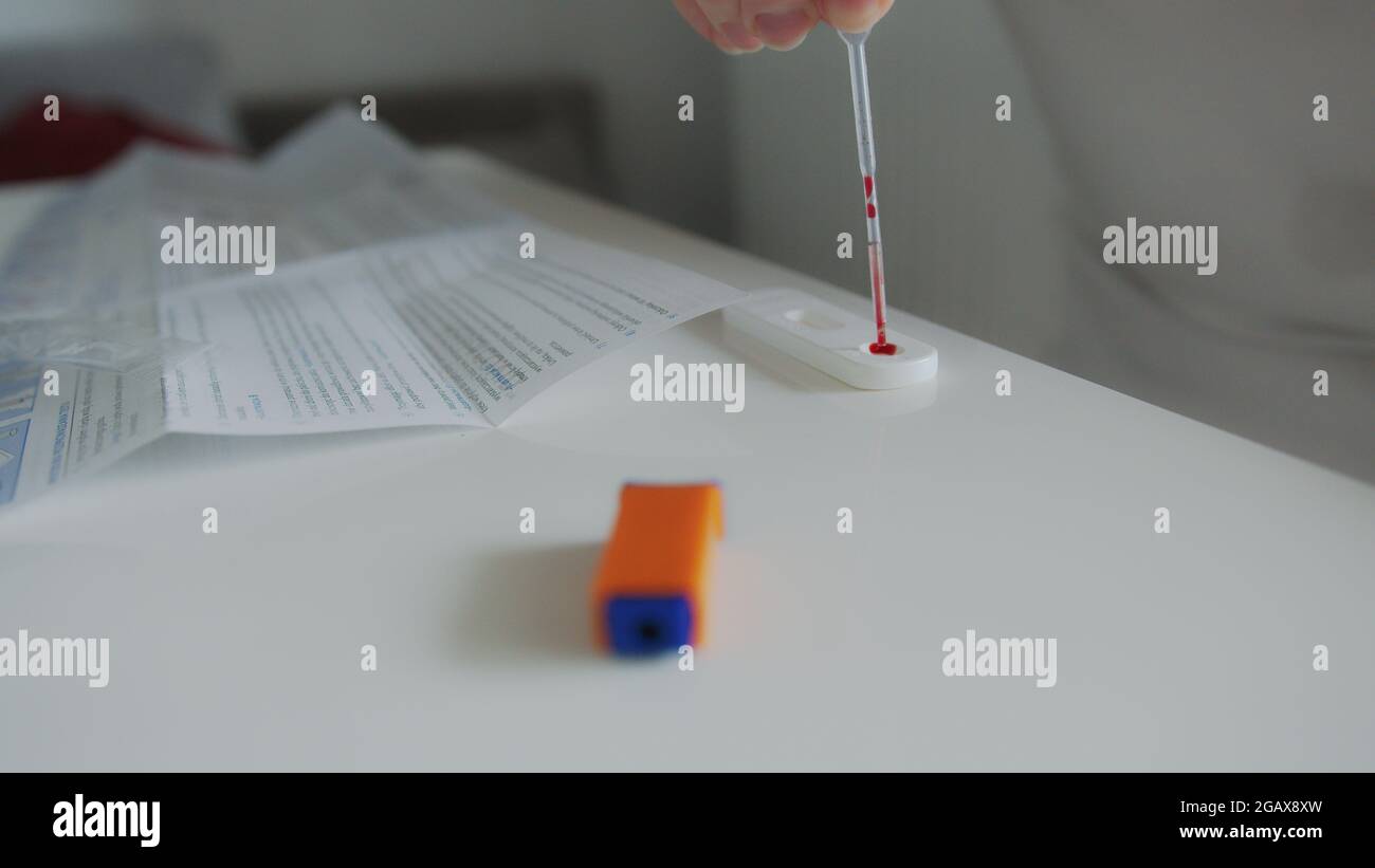 Fast blood Covid 19 test. Woman putting drops of the blood on testing ...