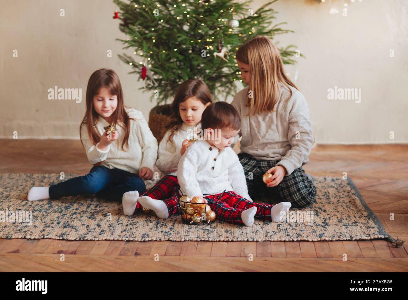 Happy four little siblings, three sisters and small brother in warm ...
