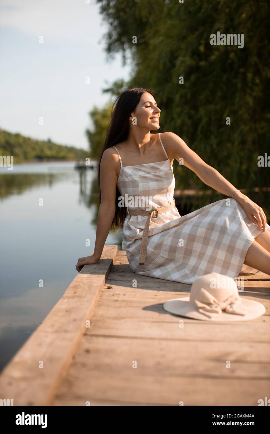 relaxing young woman on wooden pier at the calm lake Stock Photo - Alamy