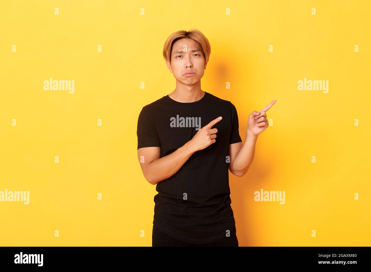 Portrait of disappointed and sad handsome blond asian guy, sulking ...