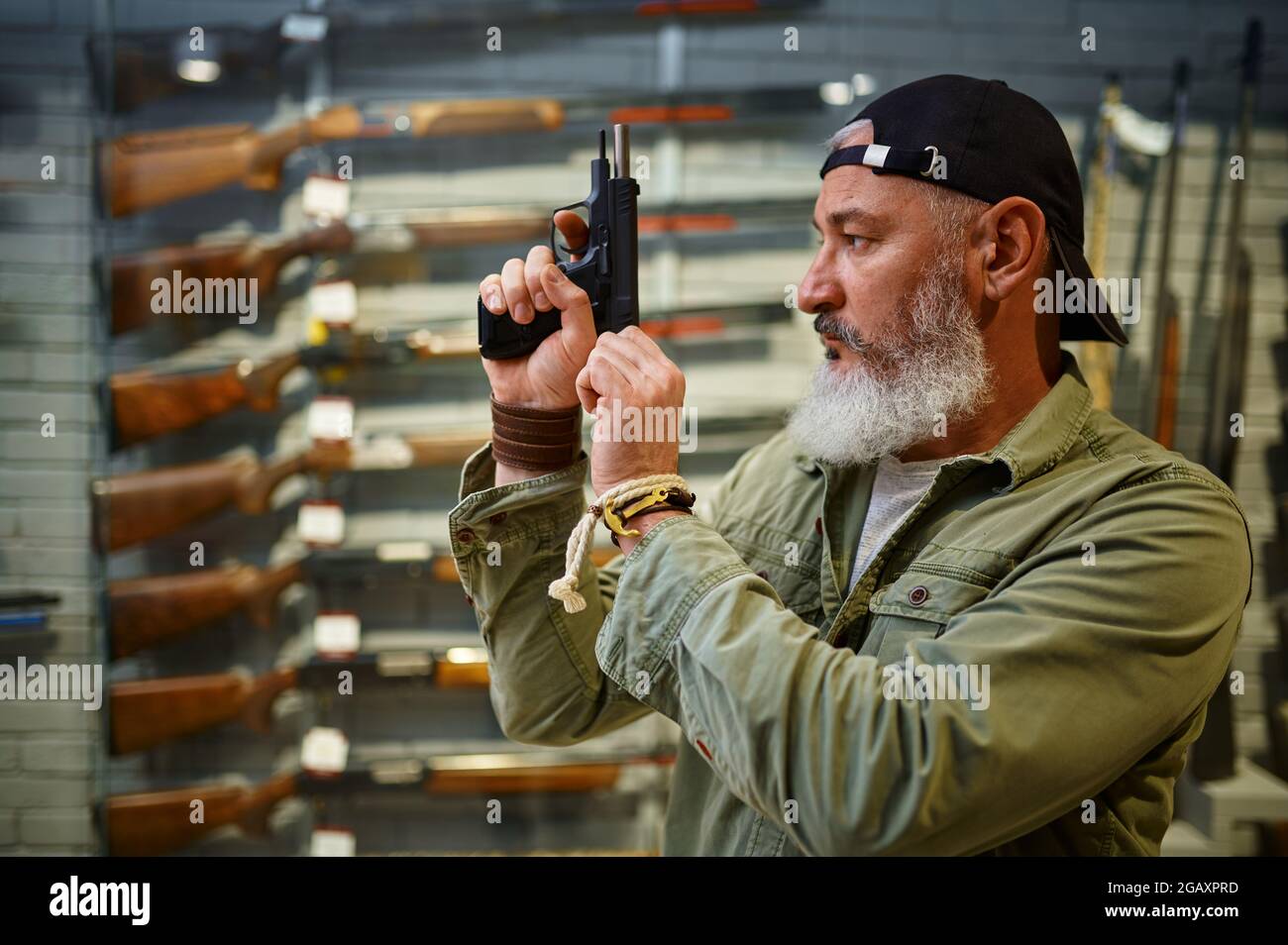 Bearded man twitches the pistol bolt in gun store Stock Photo - Alamy