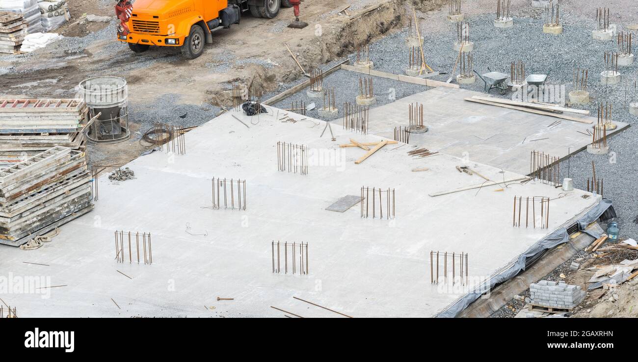 concreting work: construction site worker during concrete pouring into ...