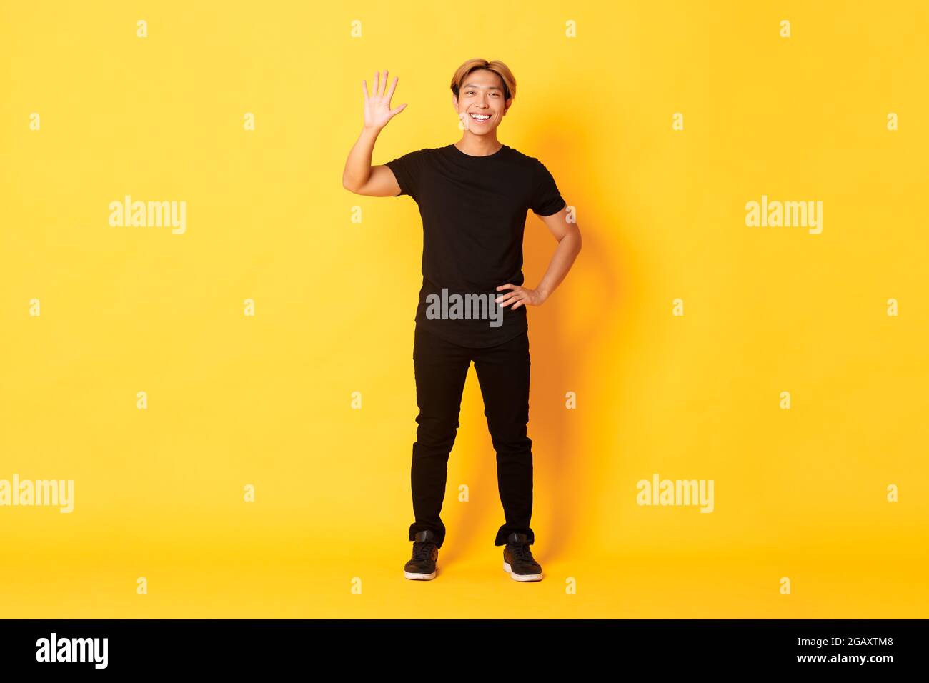 Full-length of friendly handsome asian man waving hand in hello ...